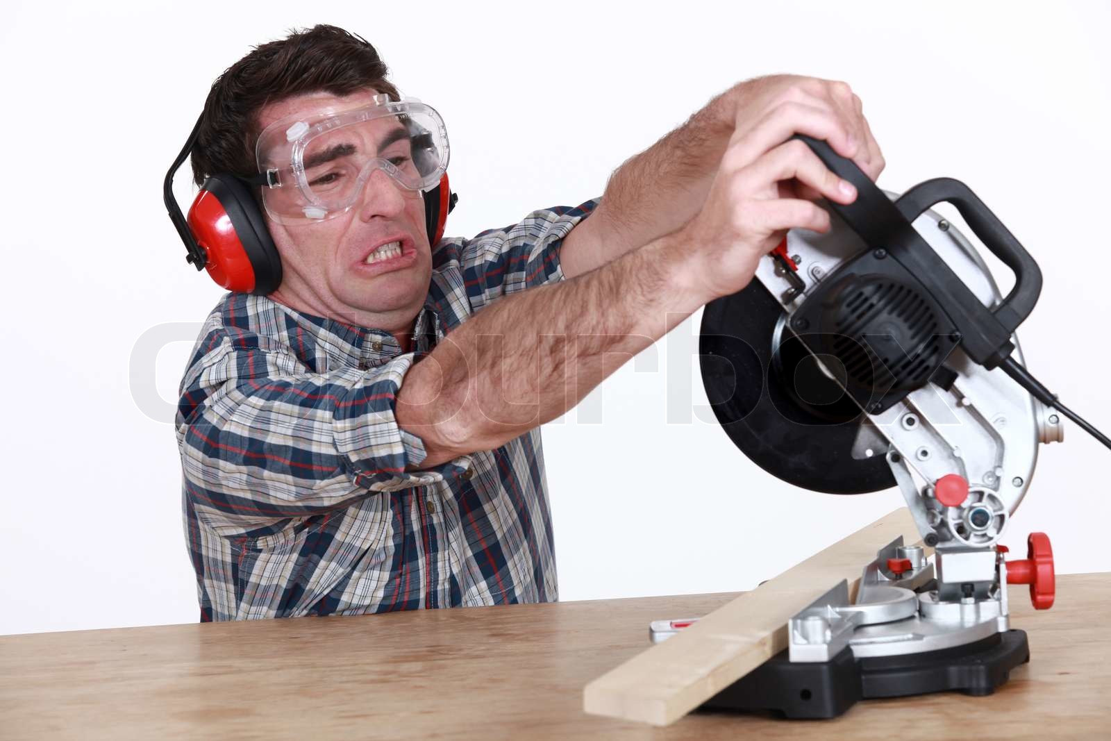 Man struggling to use a mitre saw | Stock image | Colourbox