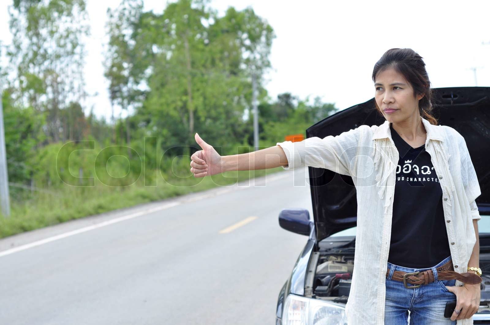 Woman trying to catch someone who may help her | Stock image | Colourbox