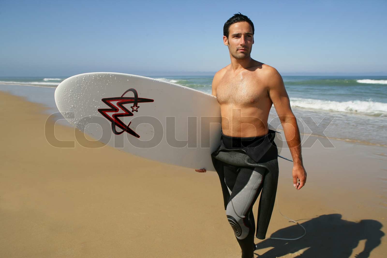 handsome surfer walking on the beach | Stock image | Colourbox