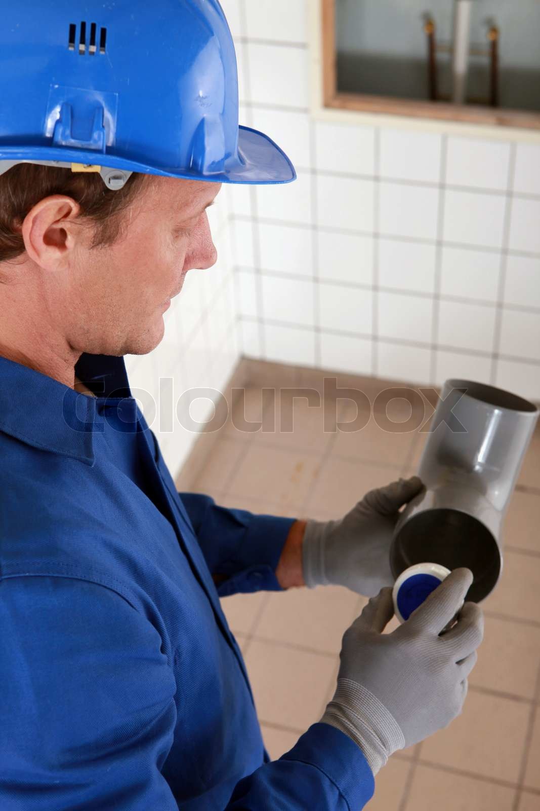 Plumber holding plastic pipe | Stock image | Colourbox
