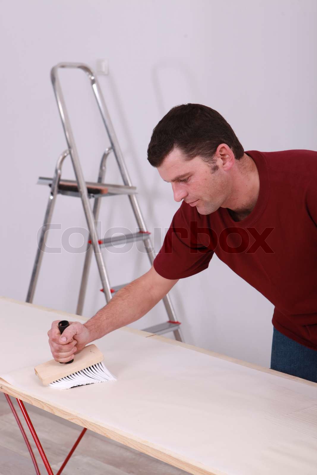 Man pasting wallpaper | Stock image | Colourbox