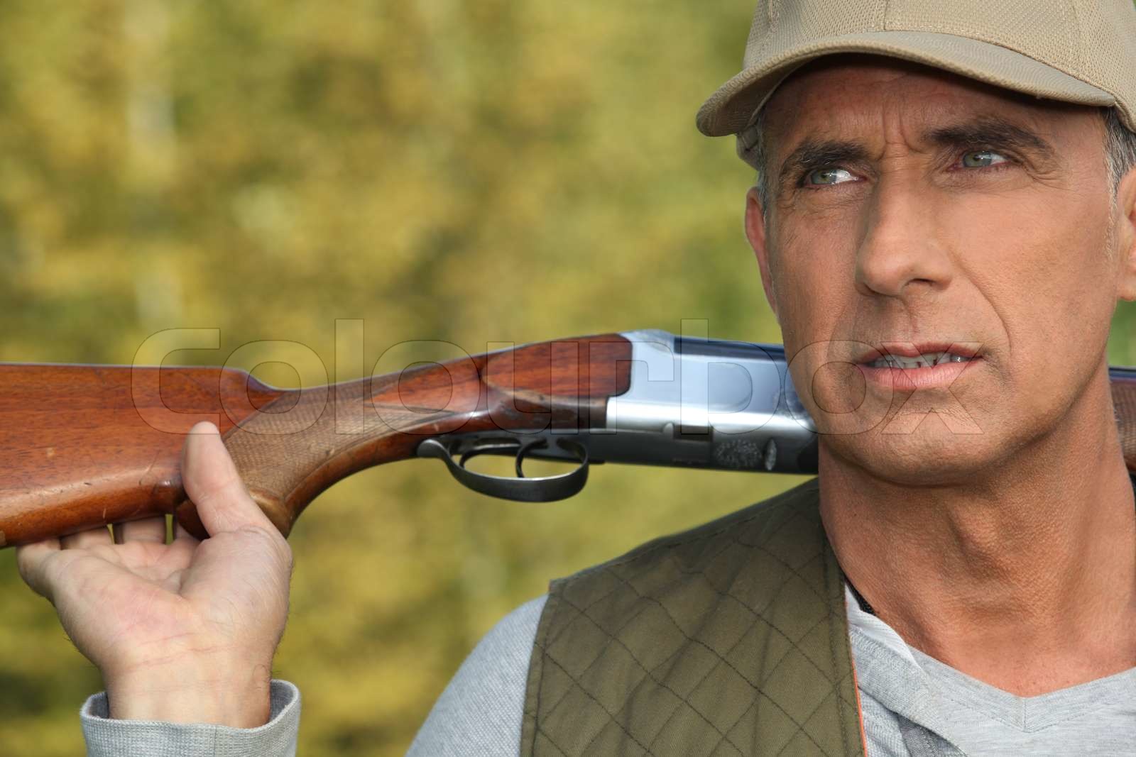 Hunter holding his shotgun over his shoulders | Stock image | Colourbox