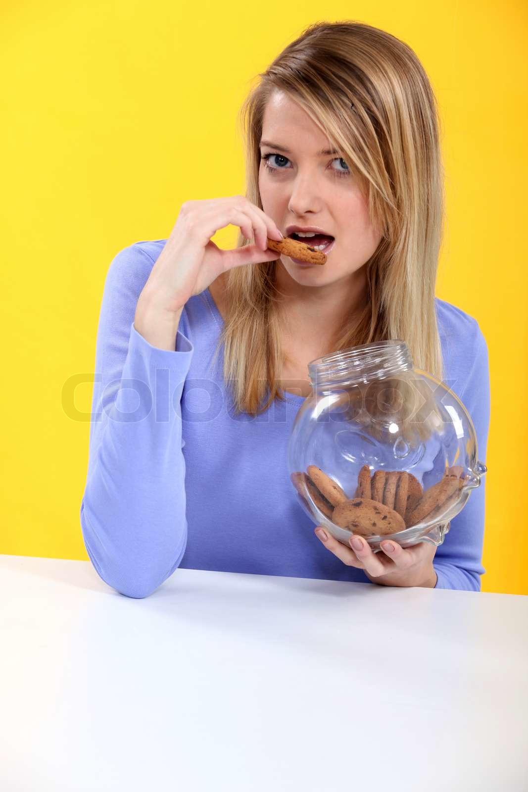 gorgeous blonde eating cookies | Stock image | Colourbox