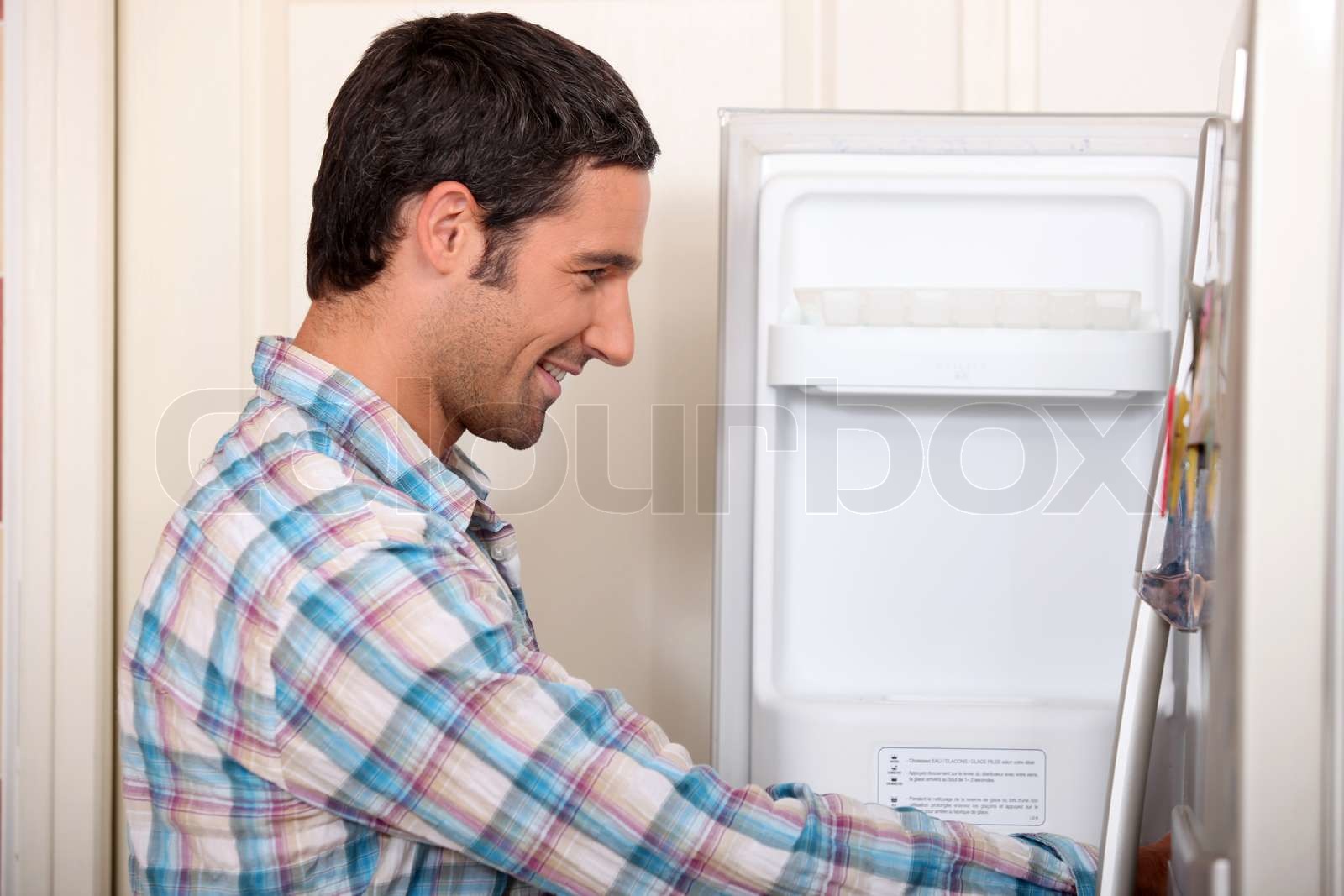 Man opening fridge door | Stock image | Colourbox