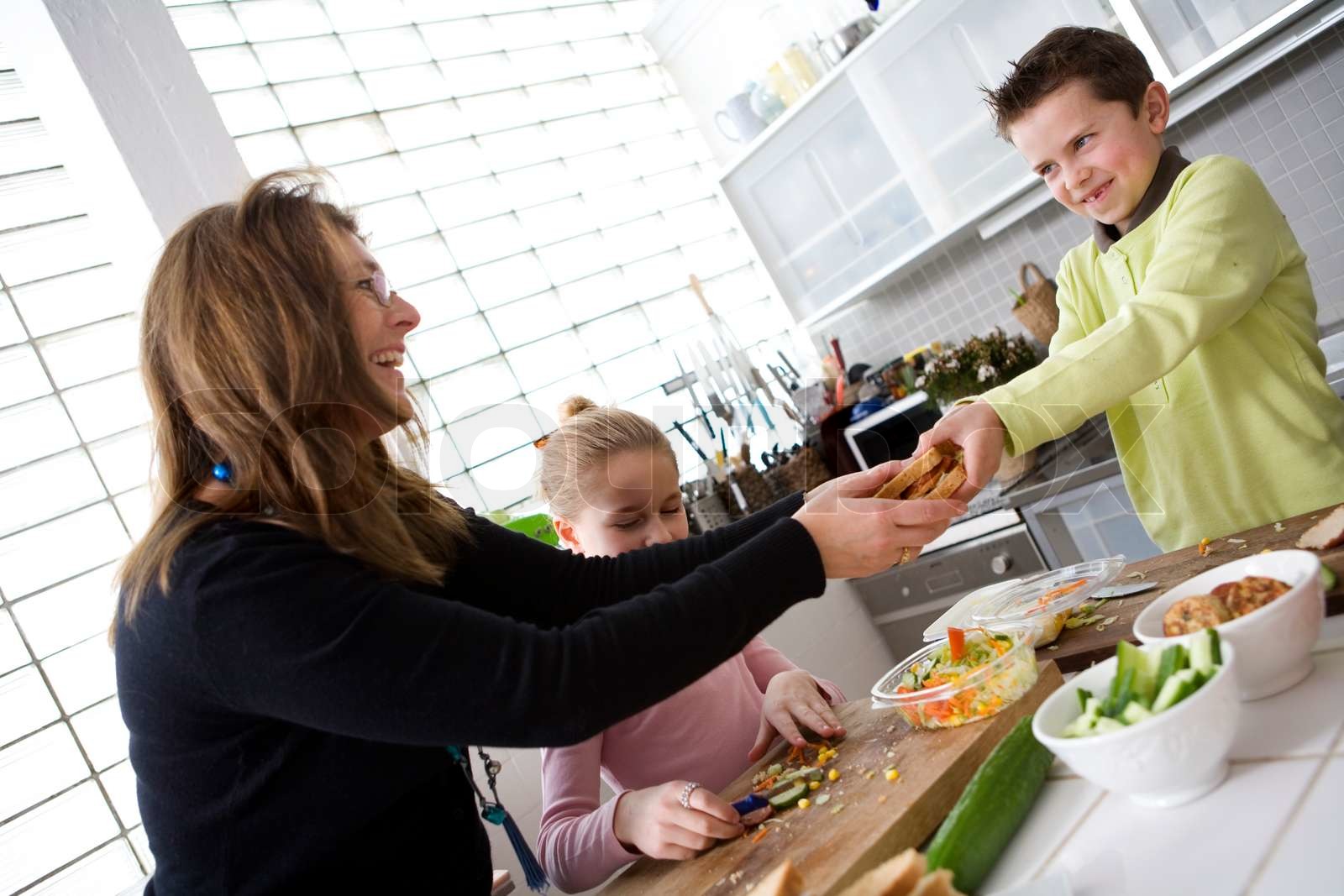 A mother and her children preparing lunch | Stock image | Colourbox