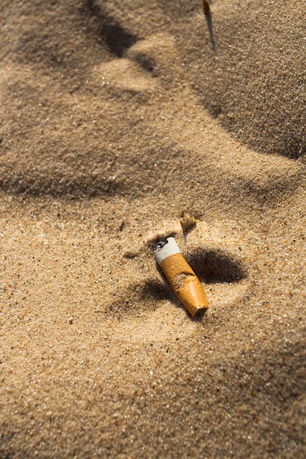 Cigarette butt in sand | Stock image | Colourbox