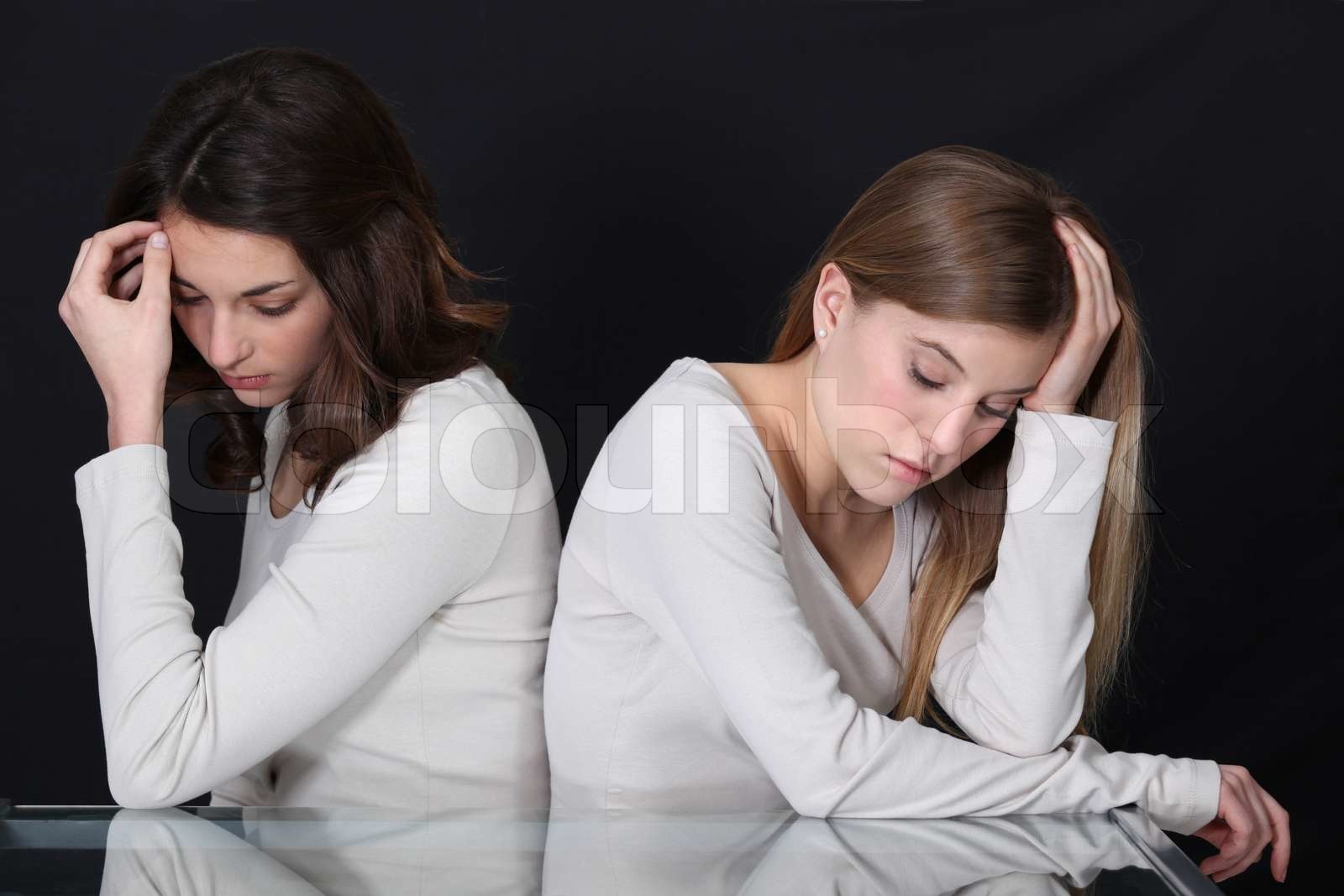 Sisters sitting back to back | Stock image | Colourbox