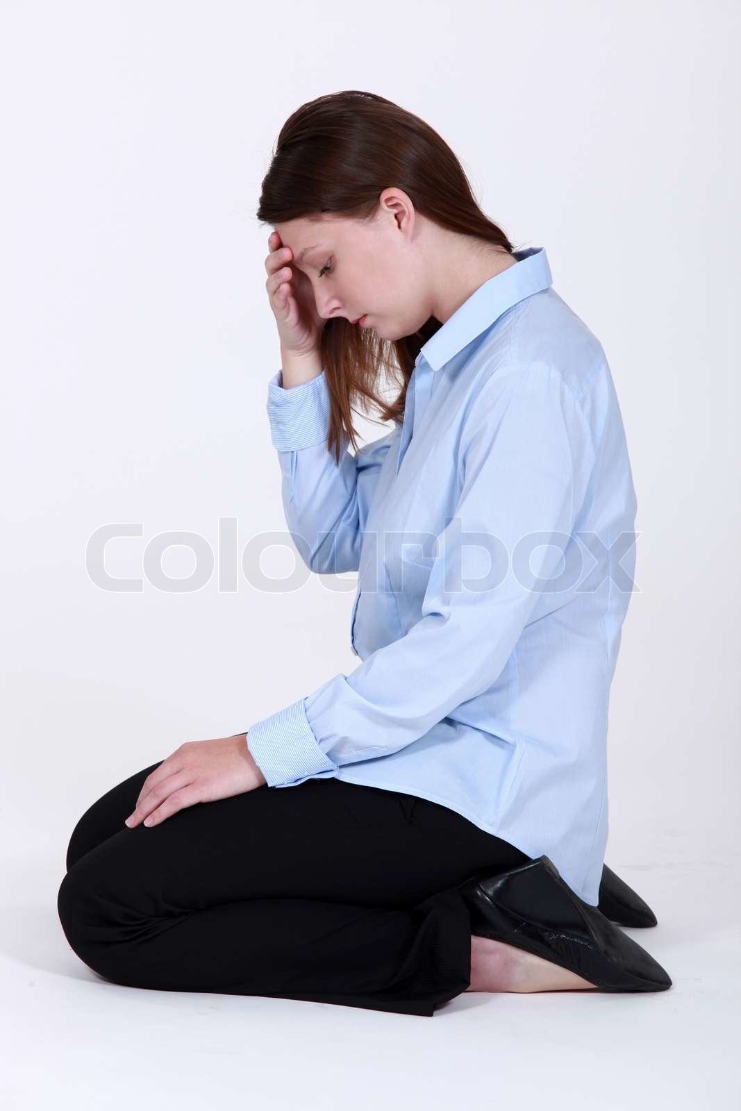 Sad woman crouching on the floor | Stock image | Colourbox