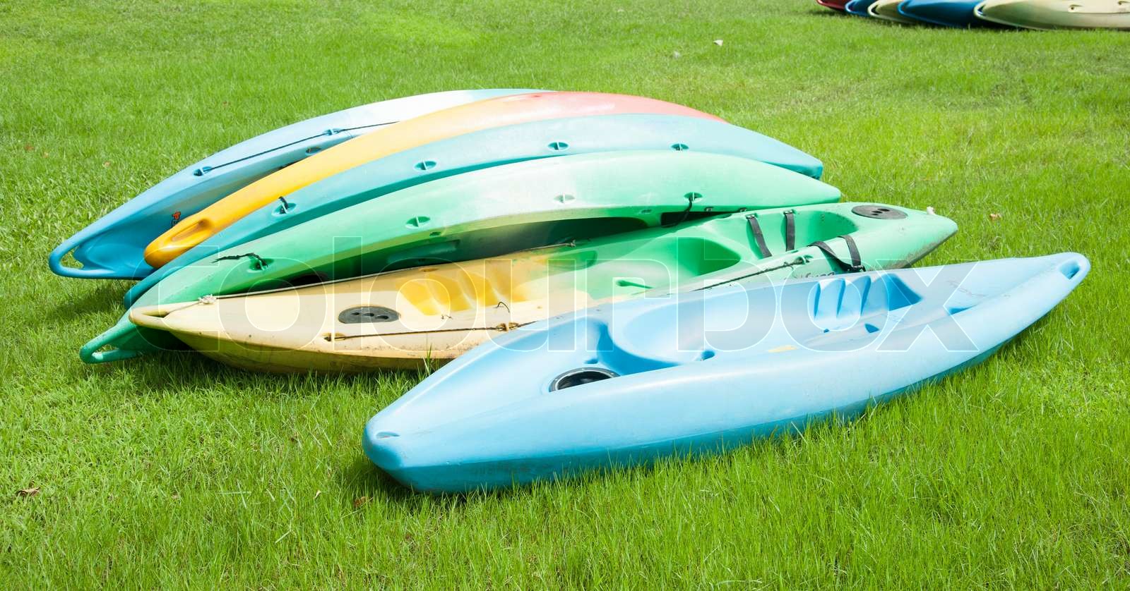 Colorful Kayaks Resting on Bright Green Grass | Stock image | Colourbox