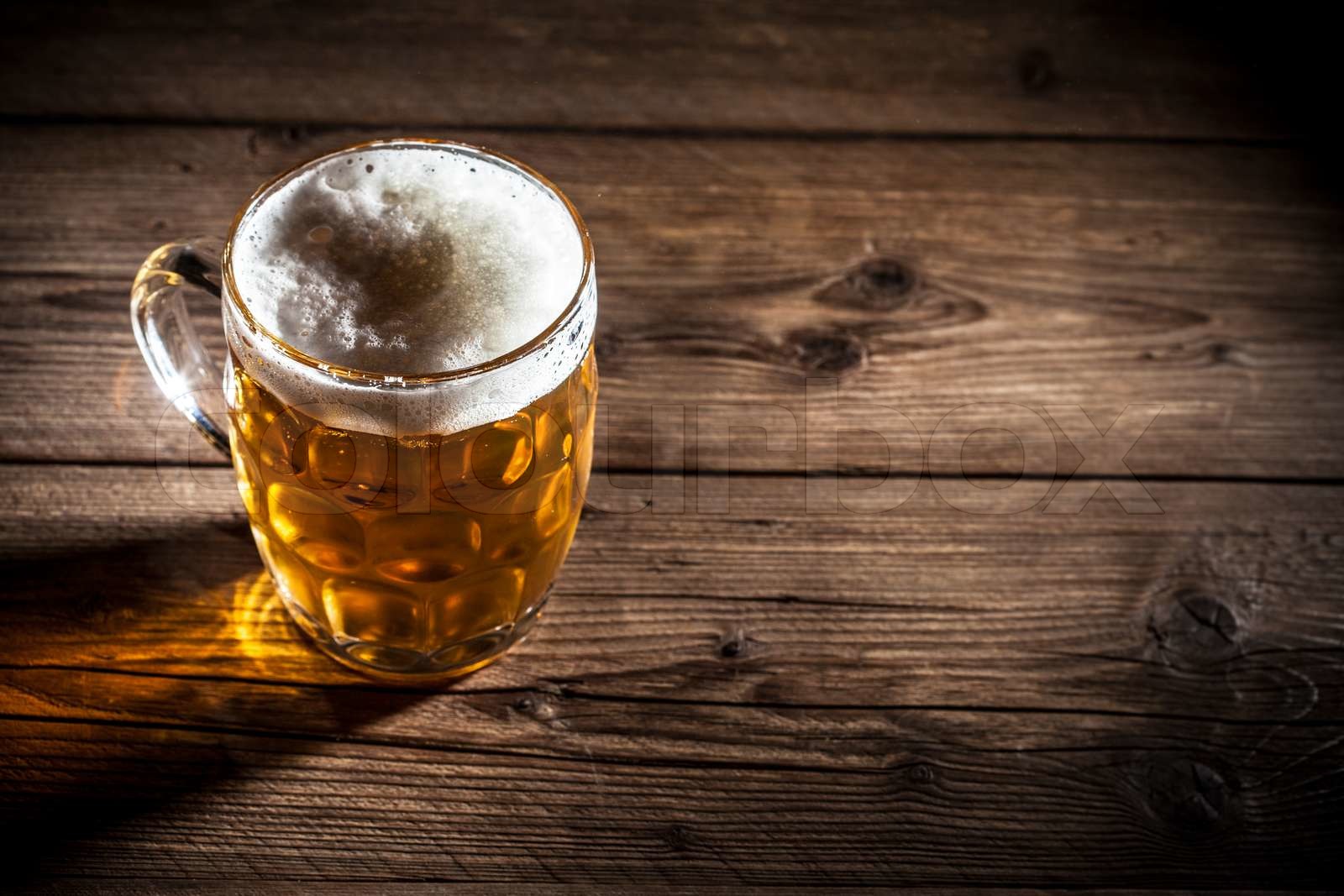 Becher Bier auf hölzernen Hintergrund | Stock Bild | Colourbox