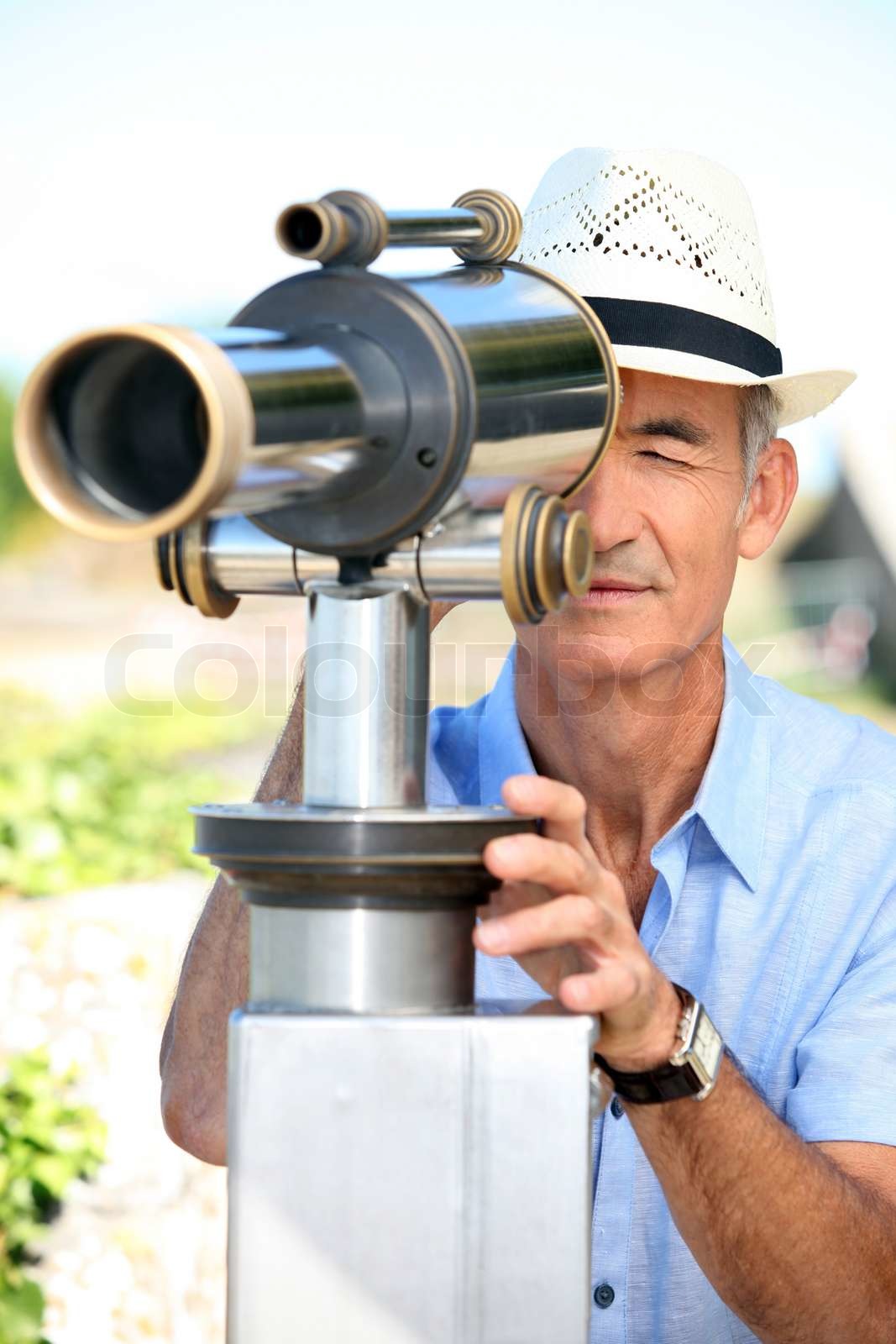 Man looking through telescope | Stock image | Colourbox