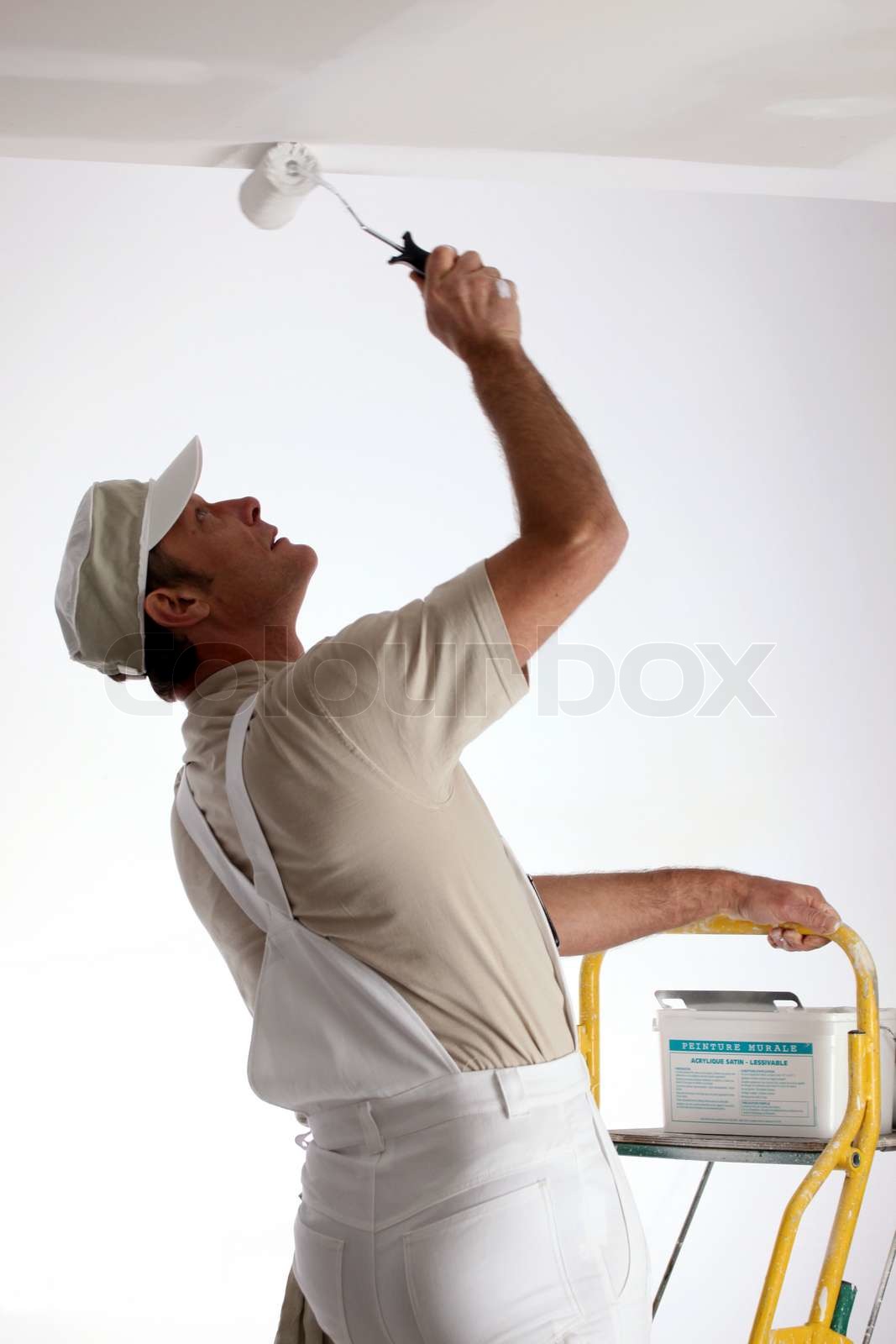 Painter using roller on ceiling | Stock image | Colourbox