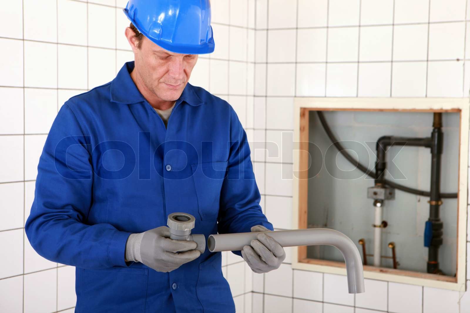 Artisan fitting two parts of pipe together | Stock image | Colourbox