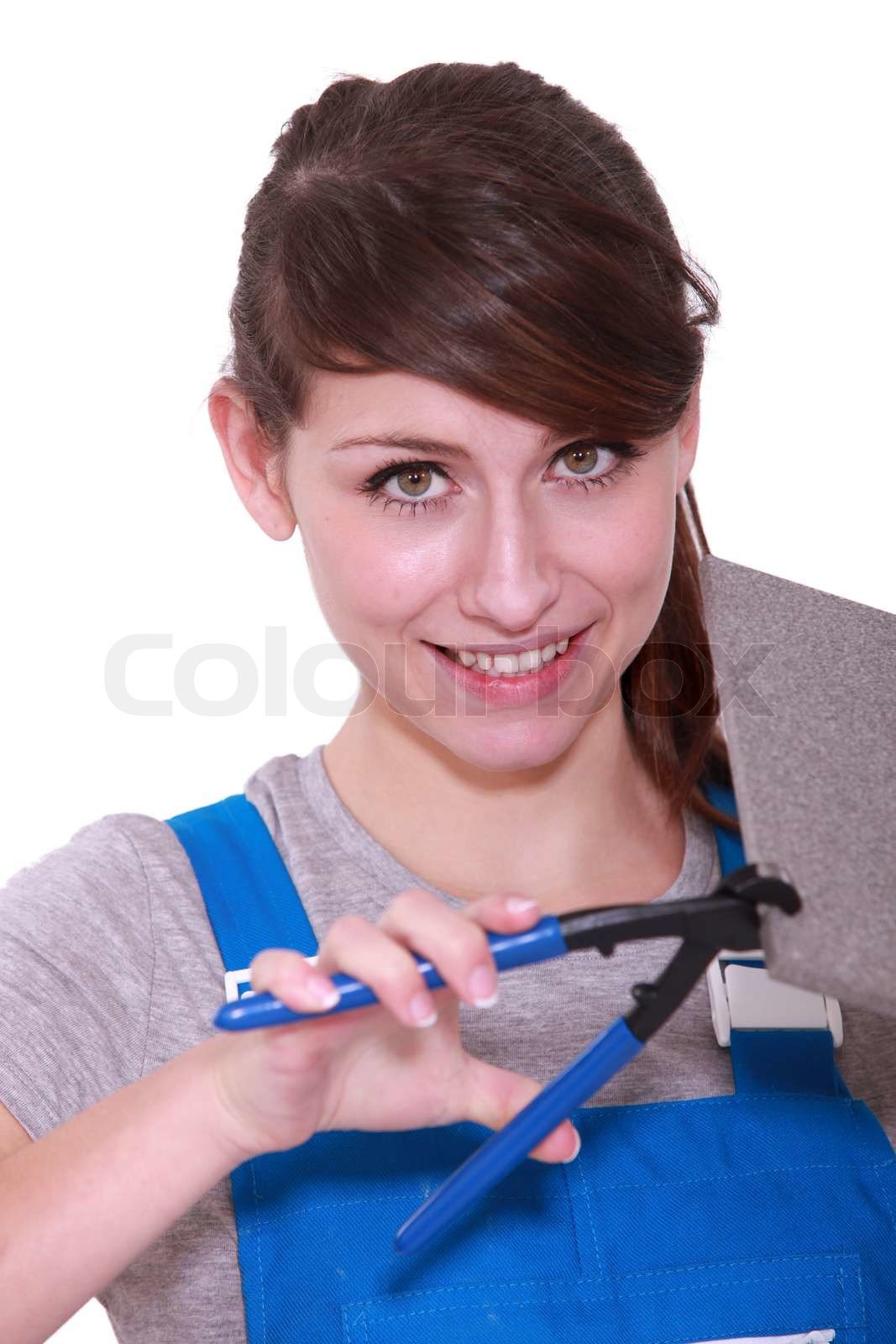 handywoman using pliers on a tile | Stock image | Colourbox