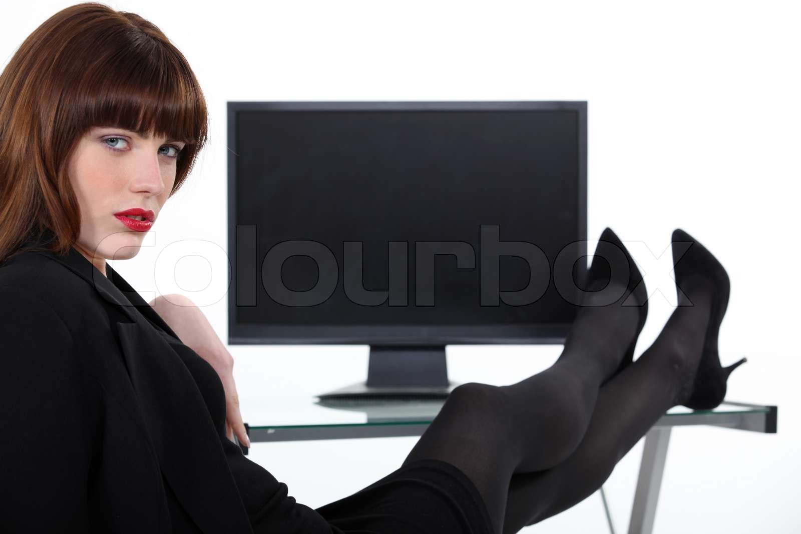 Woman resting her legs on a desk | Stock image | Colourbox