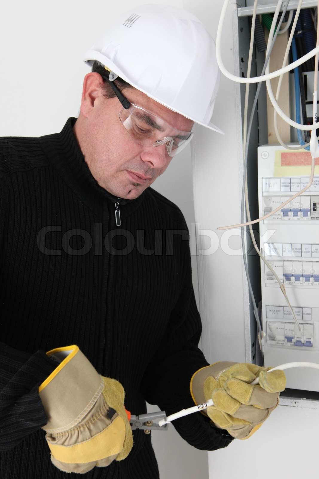 Man fixing fuse box | Stock image | Colourbox