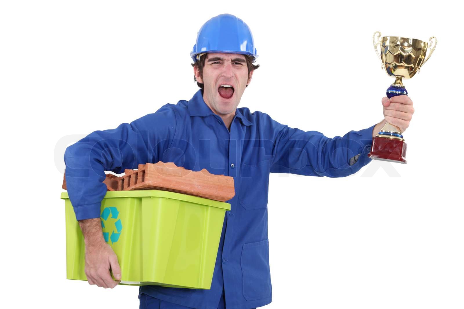 Construction worker holding a trophy | Stock image | Colourbox