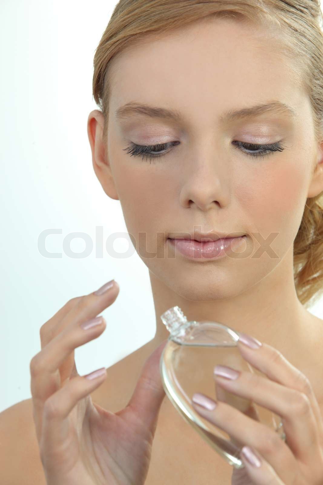 Woman putting on perfume | Stock image | Colourbox