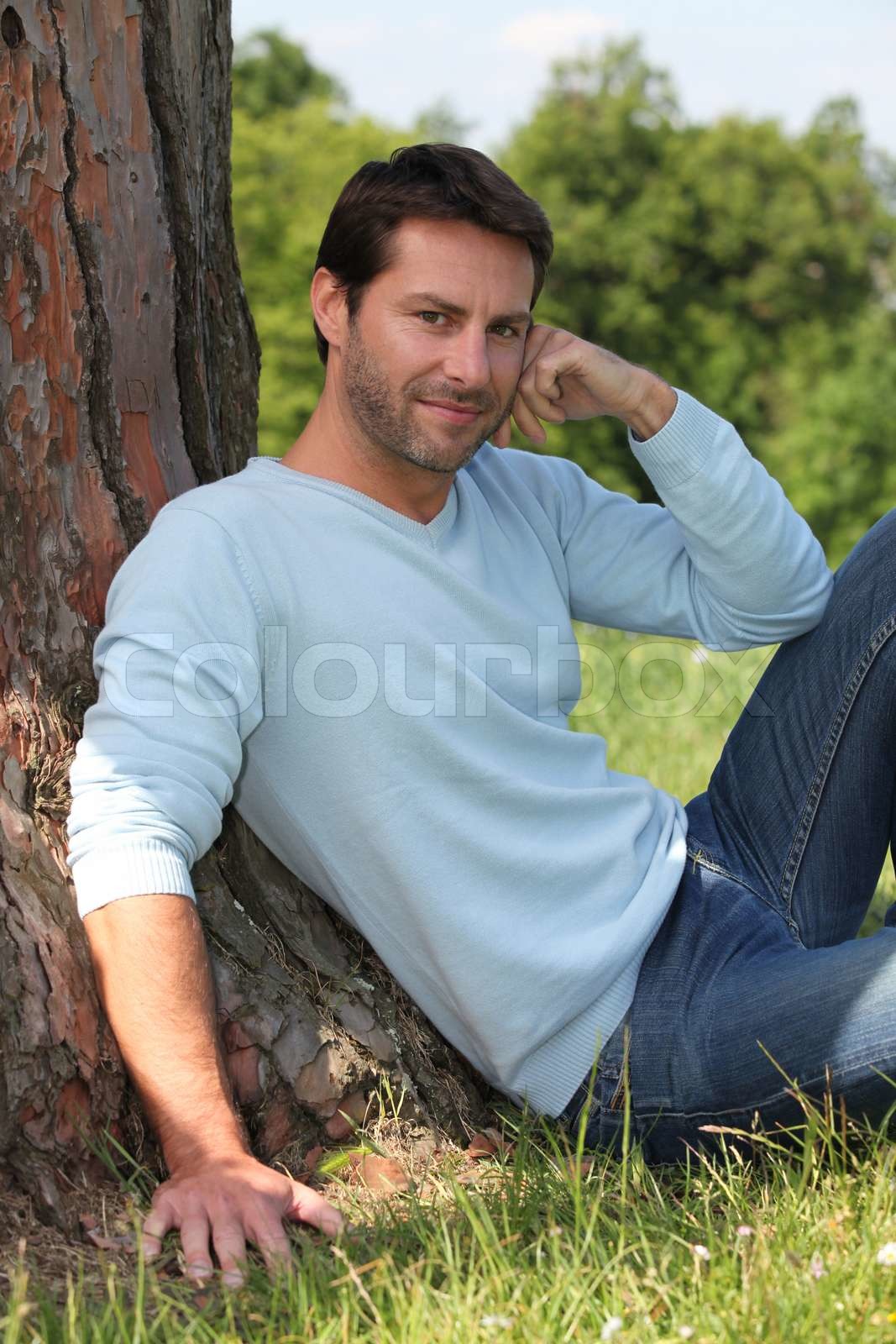 man sat against tree | Stock image | Colourbox