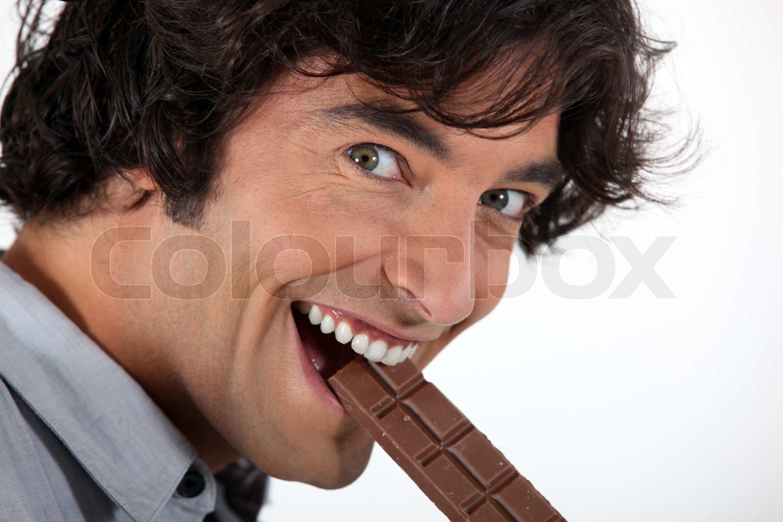 Man biting into chocolate bar | Stock image | Colourbox