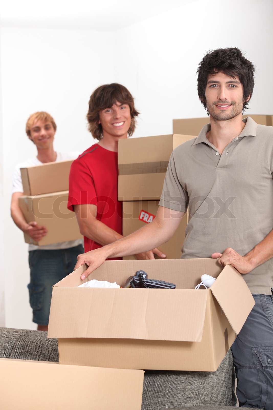 Young men moving boxes | Stock image | Colourbox