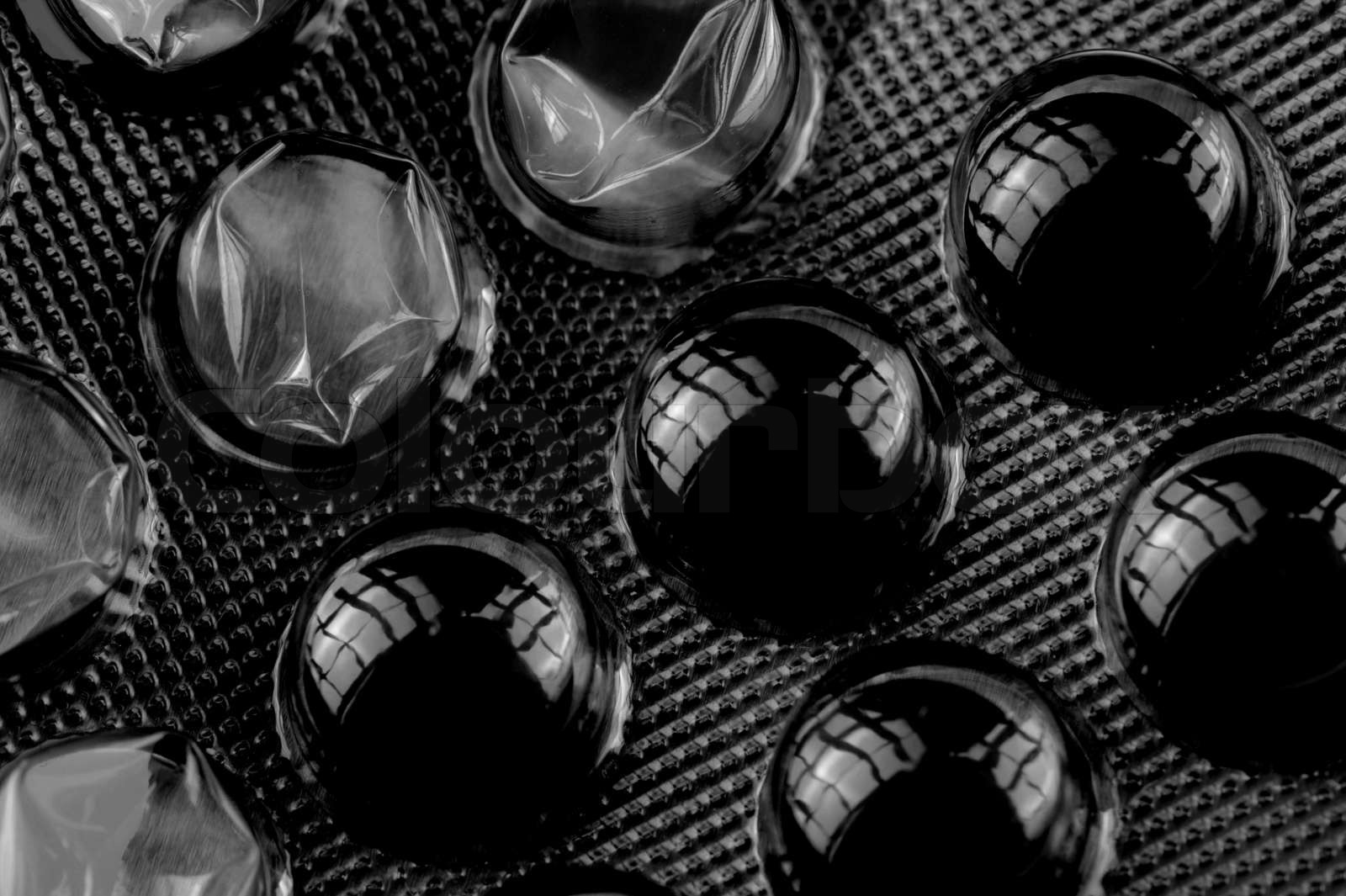 A close-up of black pills in a blister pack with a few pills missing ...