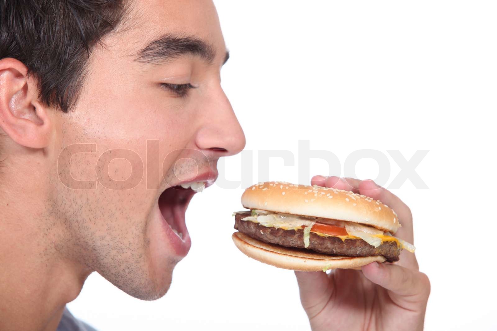 Mann isst Hamburger | Stock Bild | Colourbox