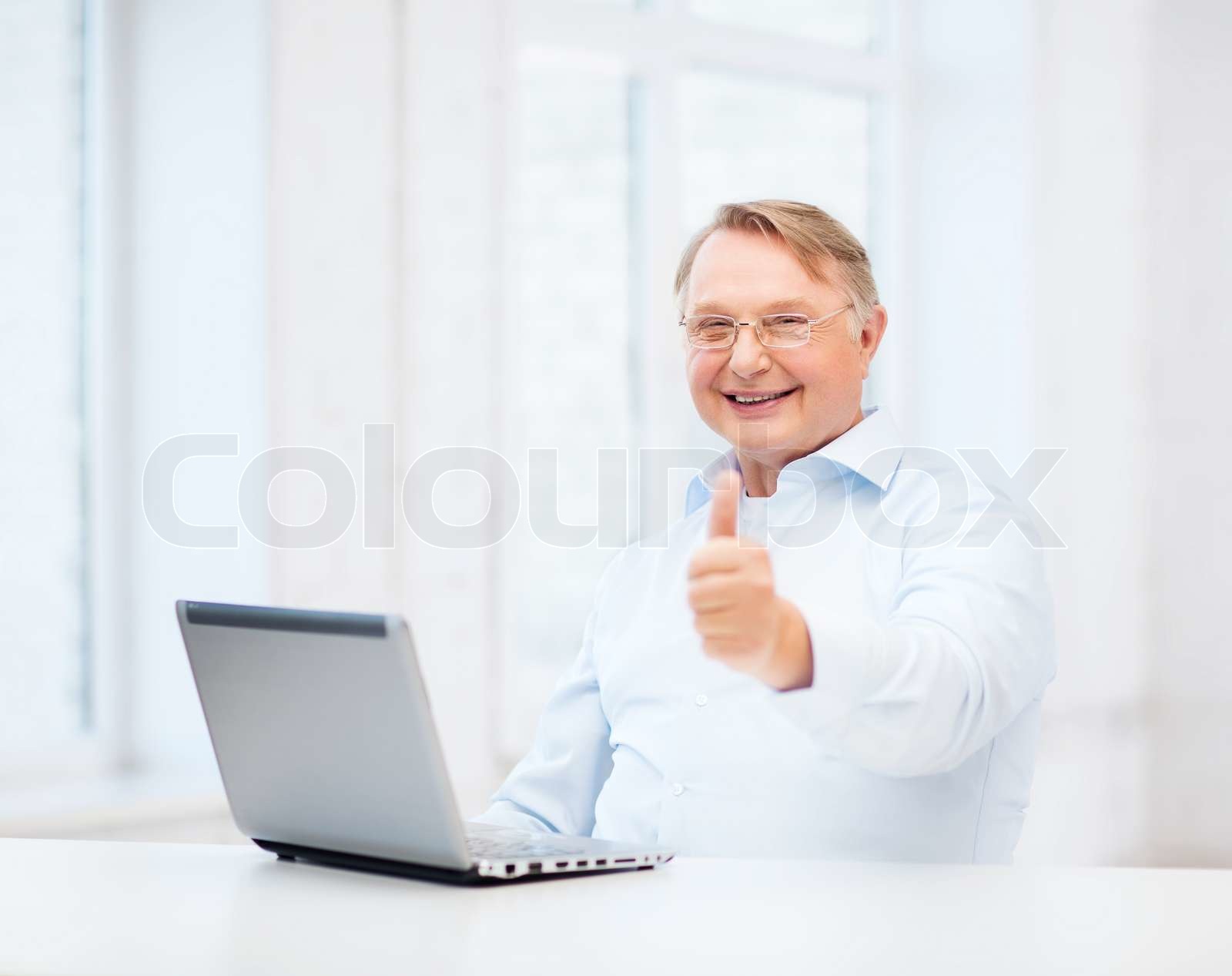 old man with laptop computer showing thumbs up | Stock image | Colourbox