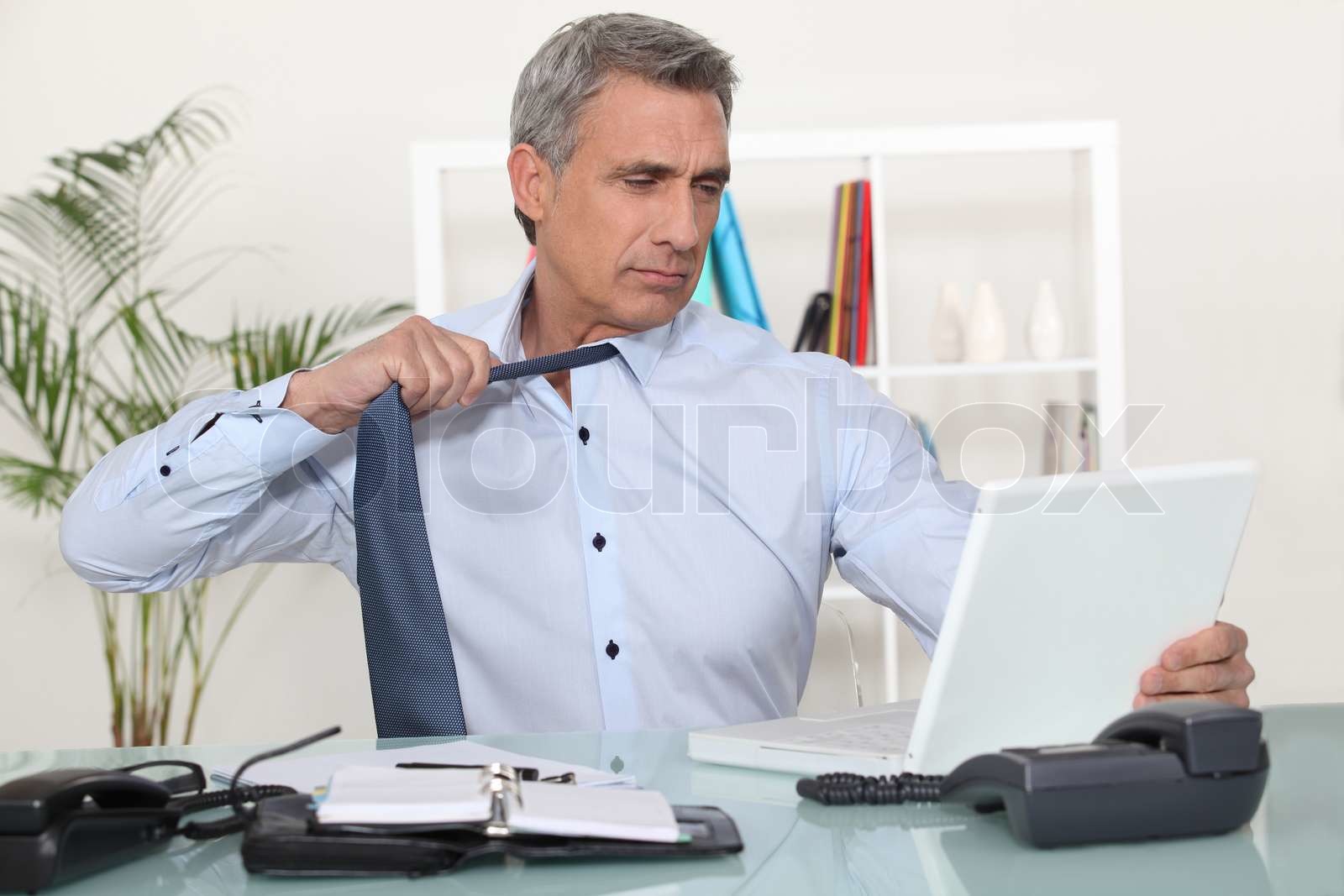 Man undoing his tie at the end of the day | Stock image | Colourbox