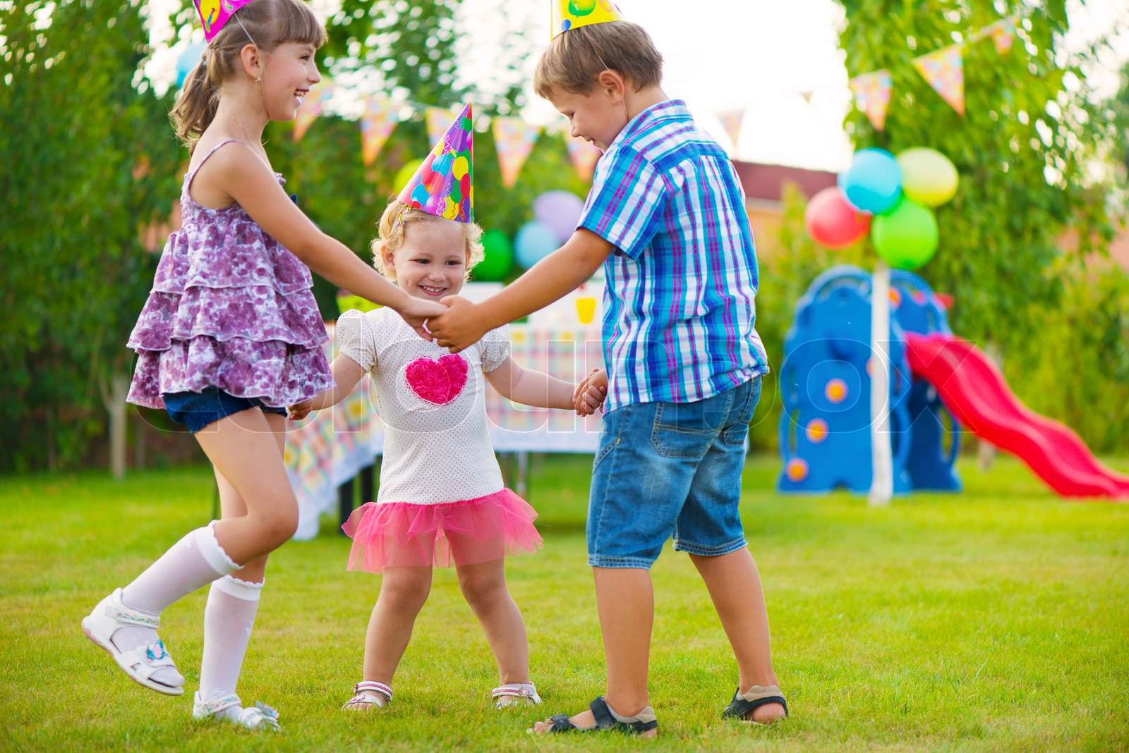 Three little kids dancing roundelay | Stock image | Colourbox