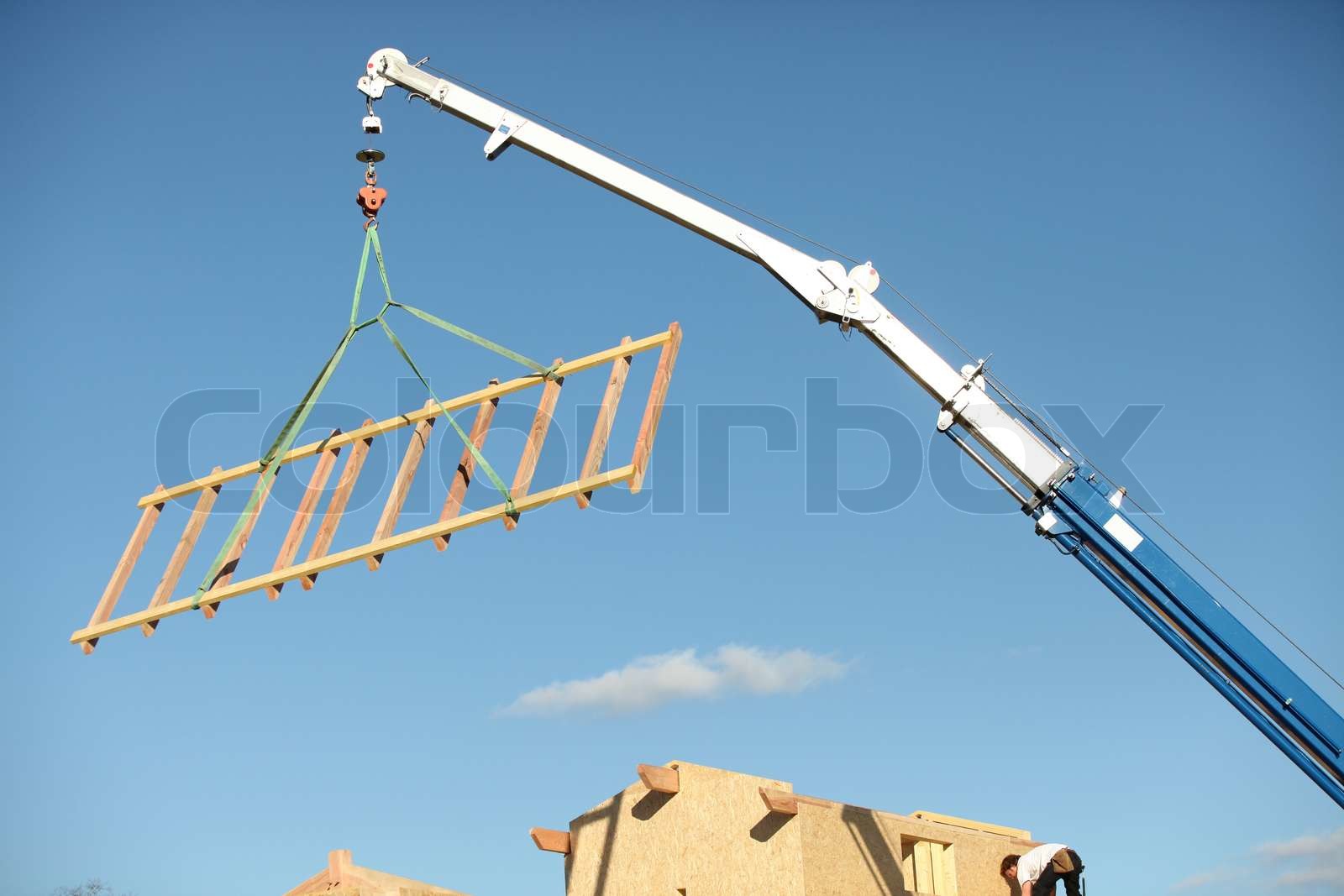 A crane lifting a wood structure | Stock image | Colourbox