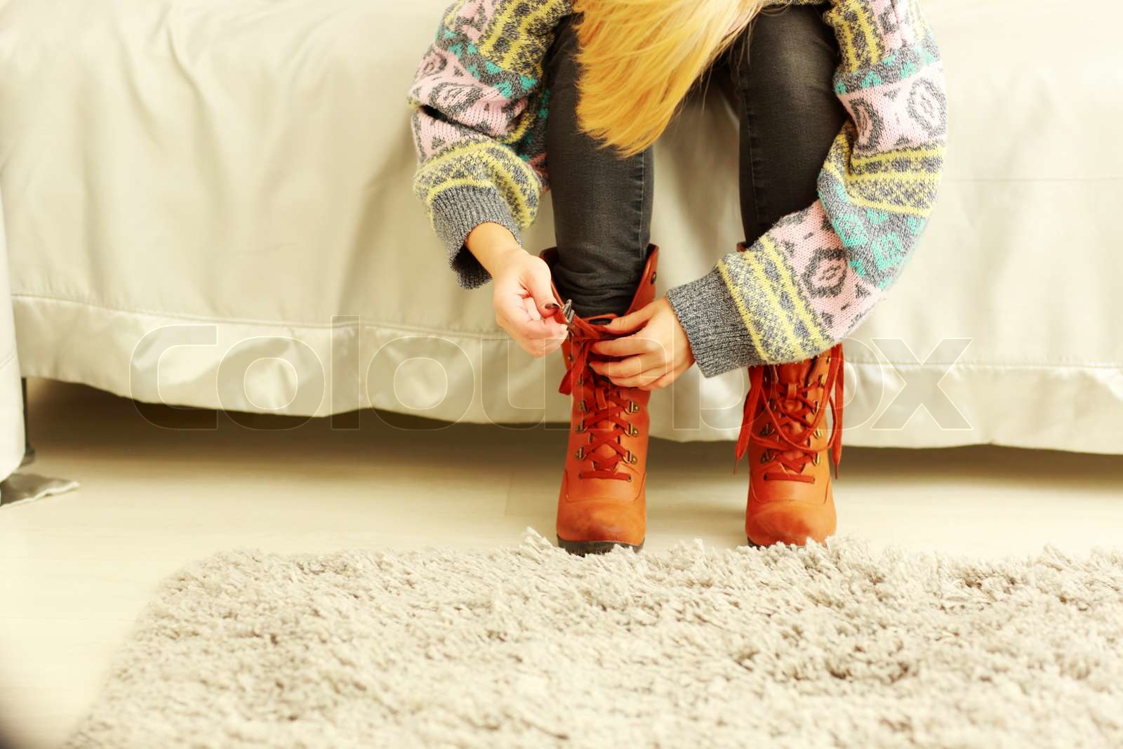 Woman taking off her boots at home | Stock image | Colourbox