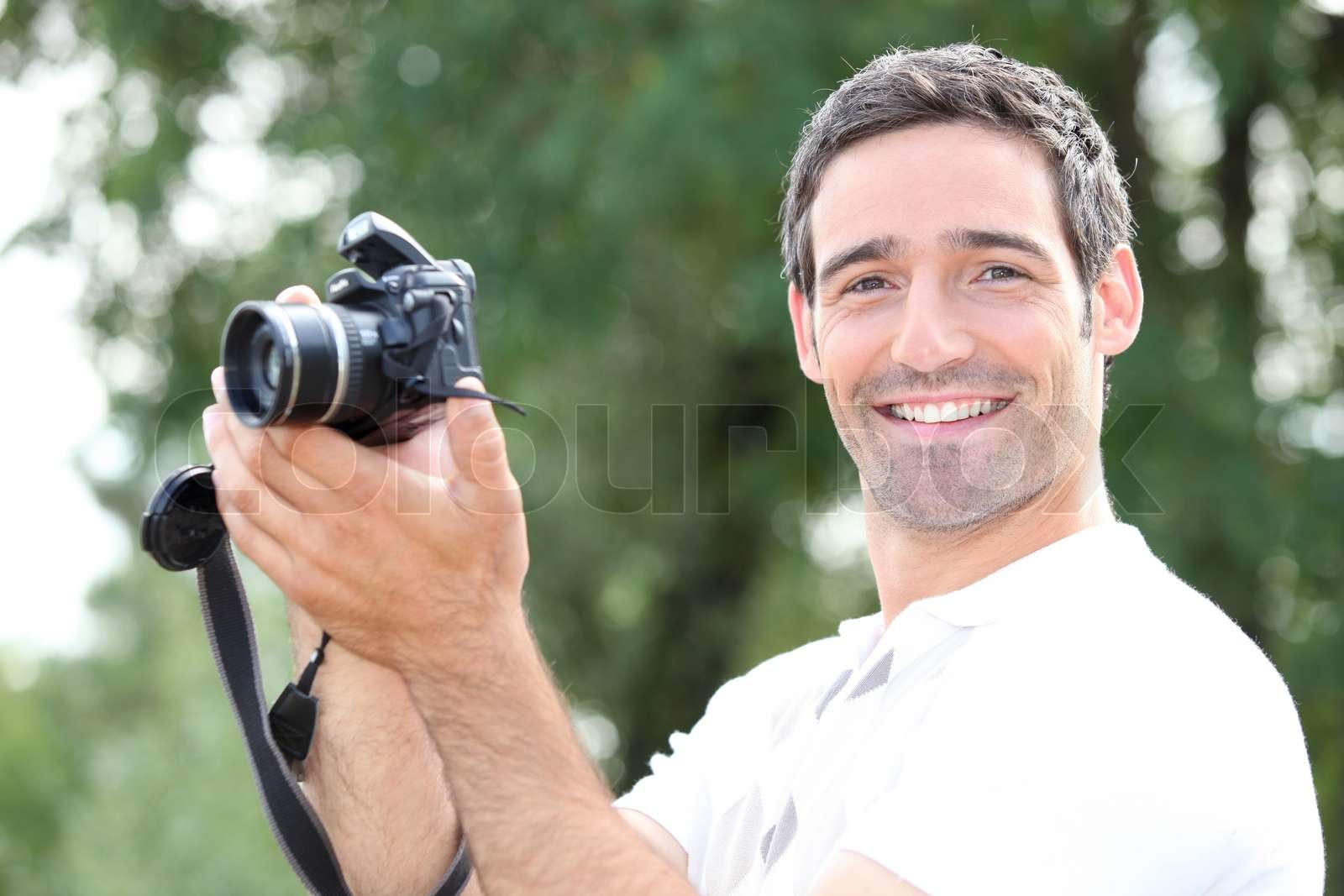 Man taking a photo with a DSLR camera | Stock image | Colourbox