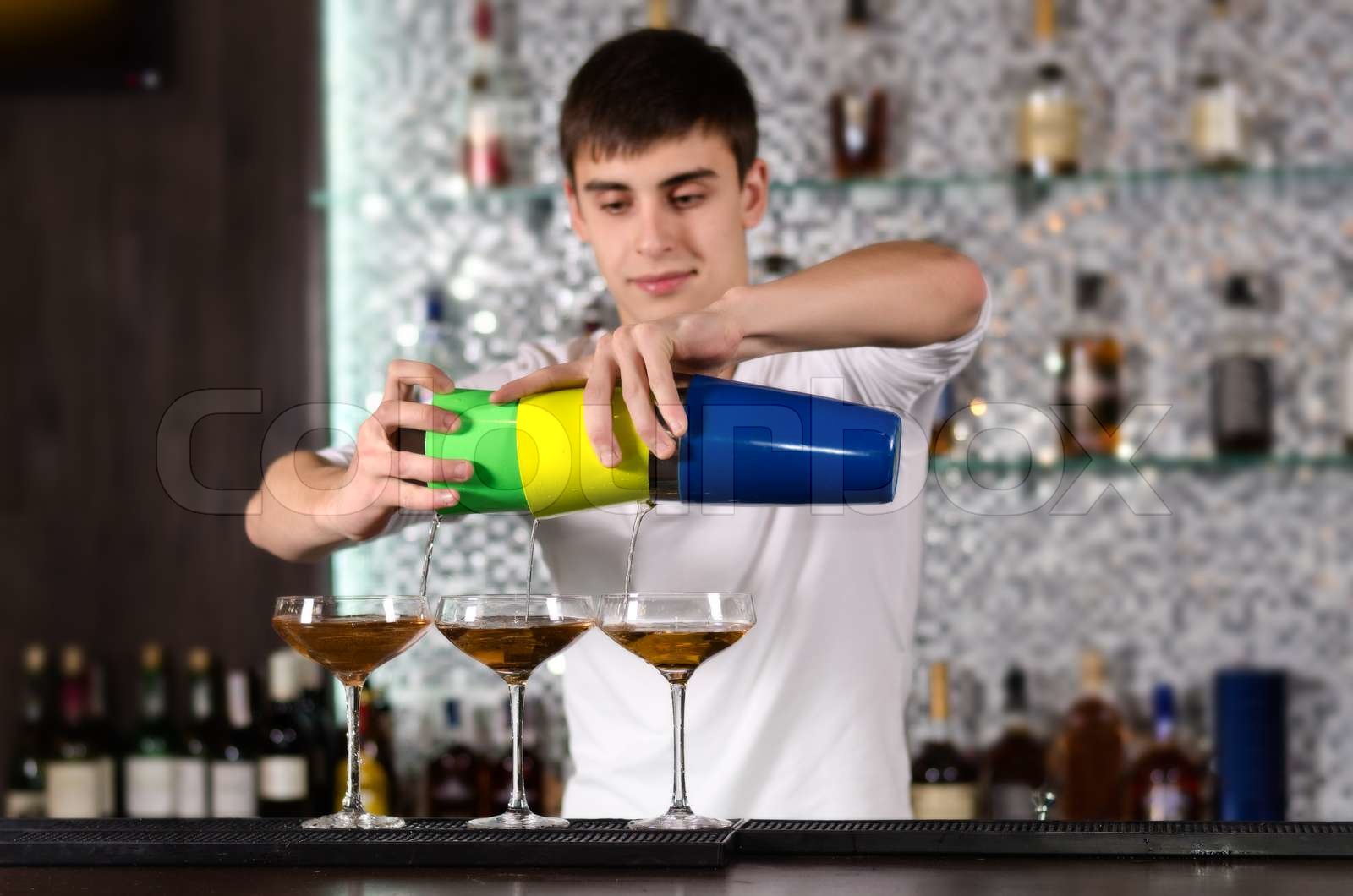 Barman pouring cocktails at the bar counter | Stock image | Colourbox