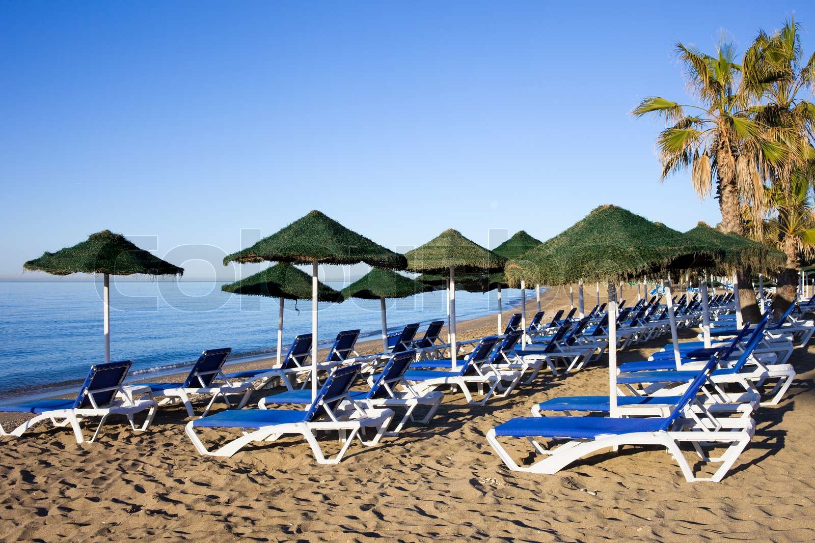 Sun loungers on a beach at the popular resort of Marbella in Spain ...
