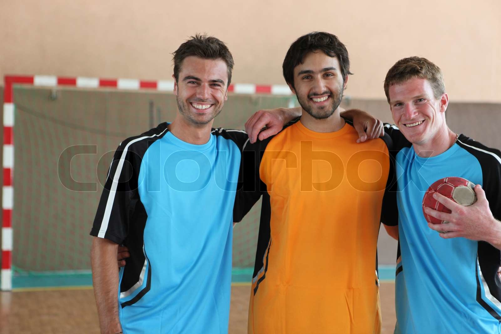 Three grinning footballers in front of goal | Stock image | Colourbox