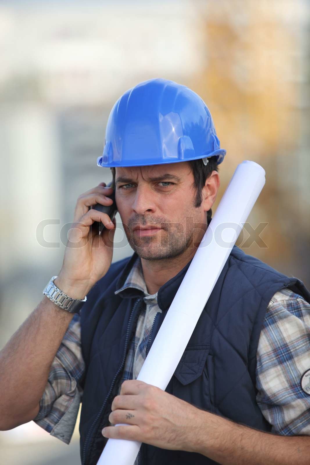 Construction worker on site with a phone | Stock image | Colourbox