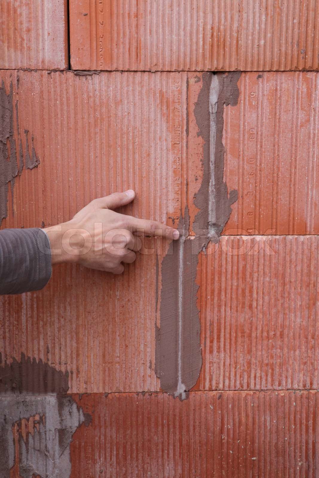 Man pointing out problem with wall | Stock image | Colourbox