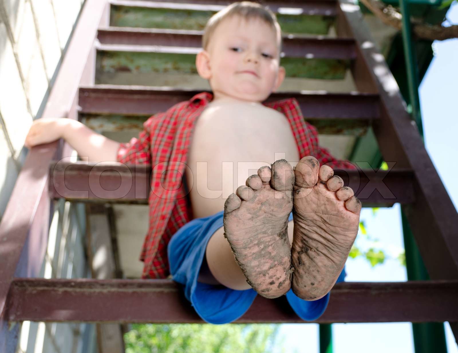 Little boy showing off his dirty feet | Stock image | Colourbox
