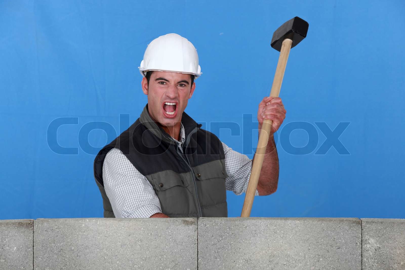 Angry man holding sledge-hammer | Stock image | Colourbox
