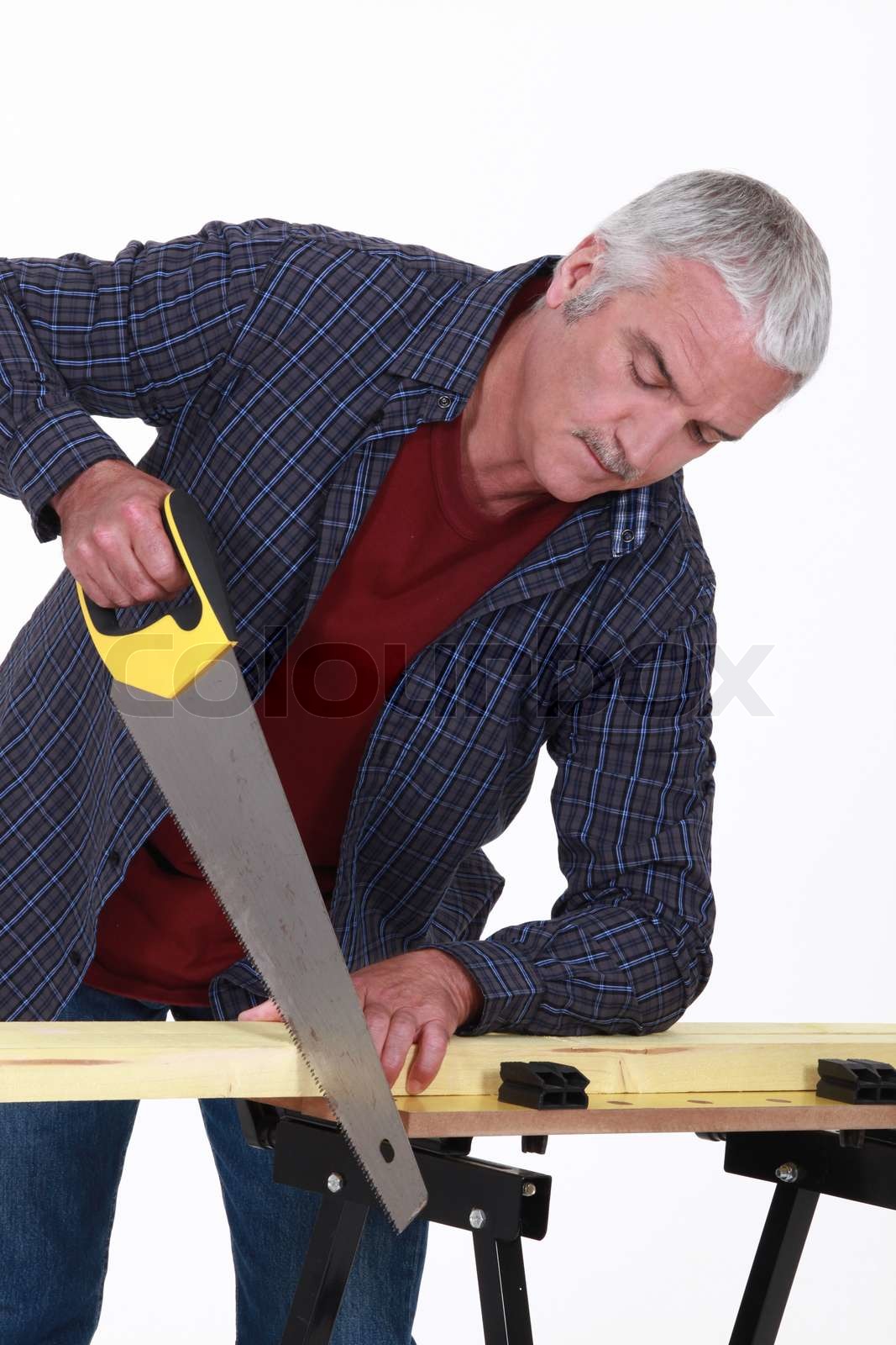 mature carpenter using saw | Stock image | Colourbox
