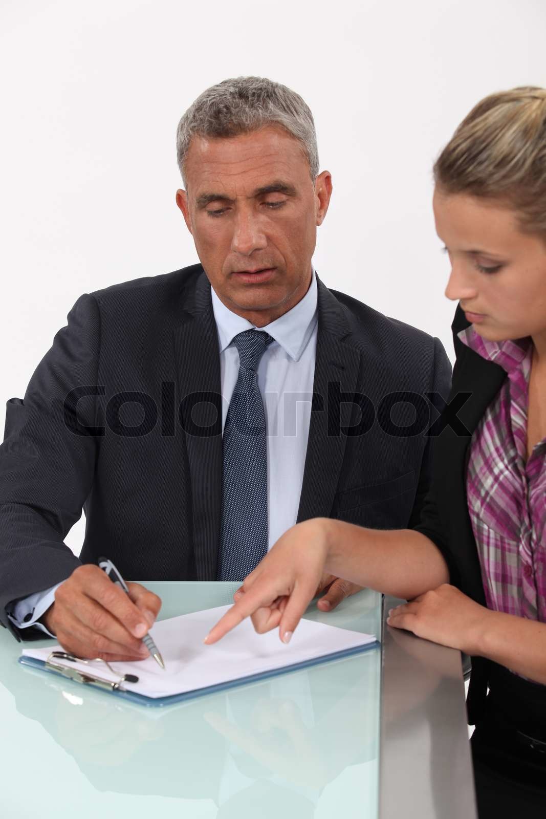 Secretary helping her boss fill in paperwork | Stock image | Colourbox