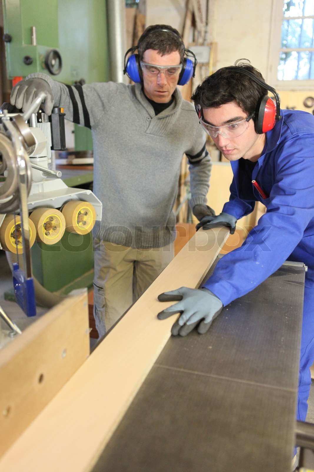 Carpenters cutting a plank of wood | Stock image | Colourbox