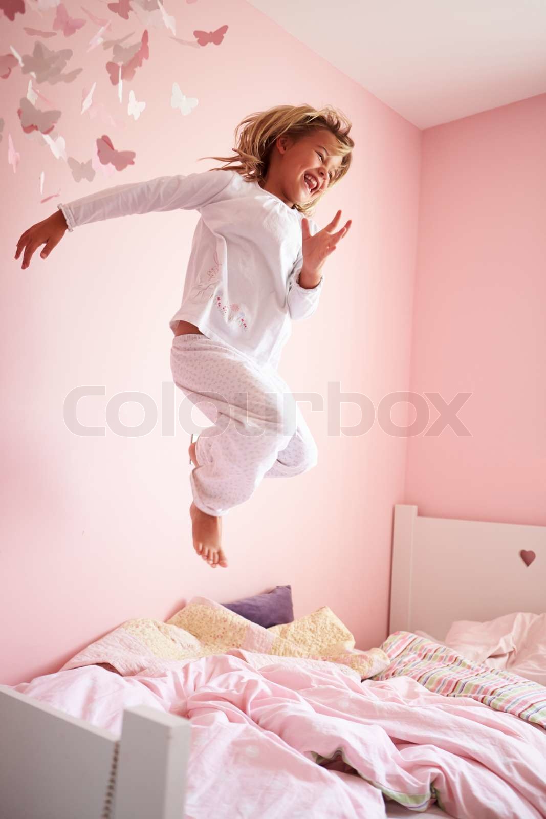 Young Girl Jumping On Her Bed | Stock image | Colourbox