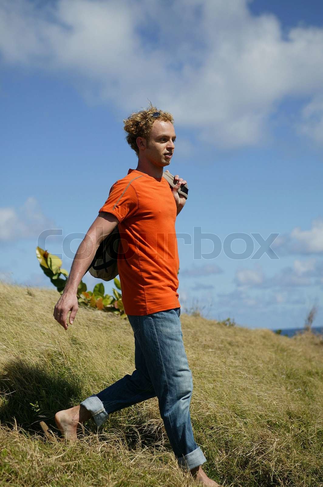 Man walking through field with backpack | Stock image | Colourbox