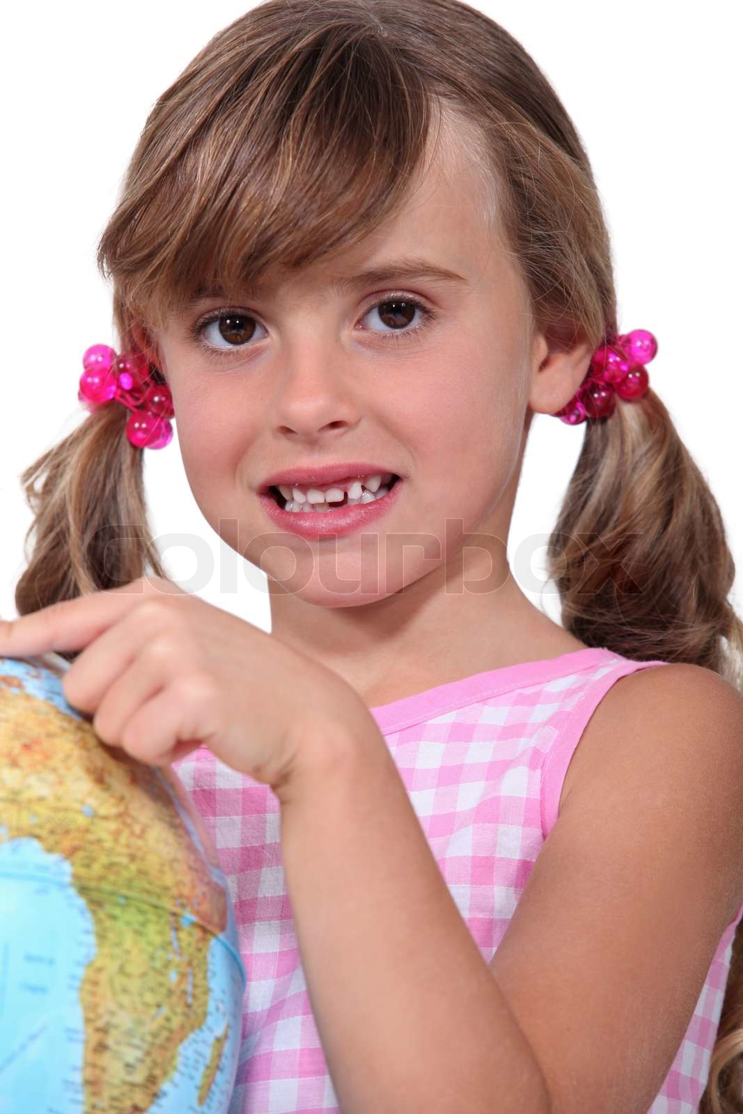 Young schoolgirl pointing to a destination on a globe | Stock image ...