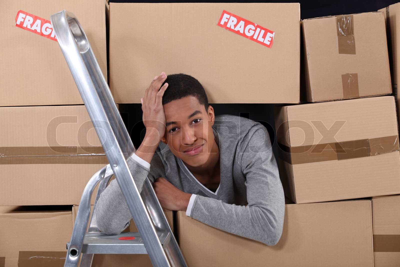 Young man surrounded by boxes | Stock image | Colourbox