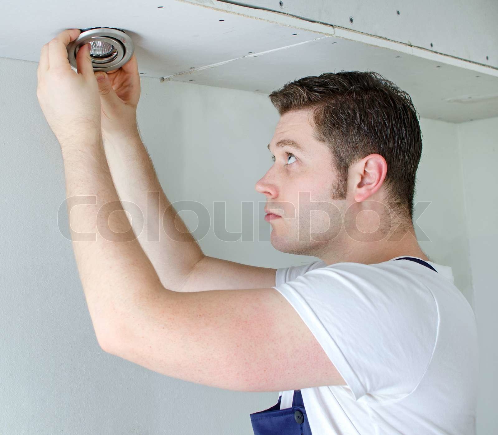 Certified electrician installing light bulb | Stock image | Colourbox