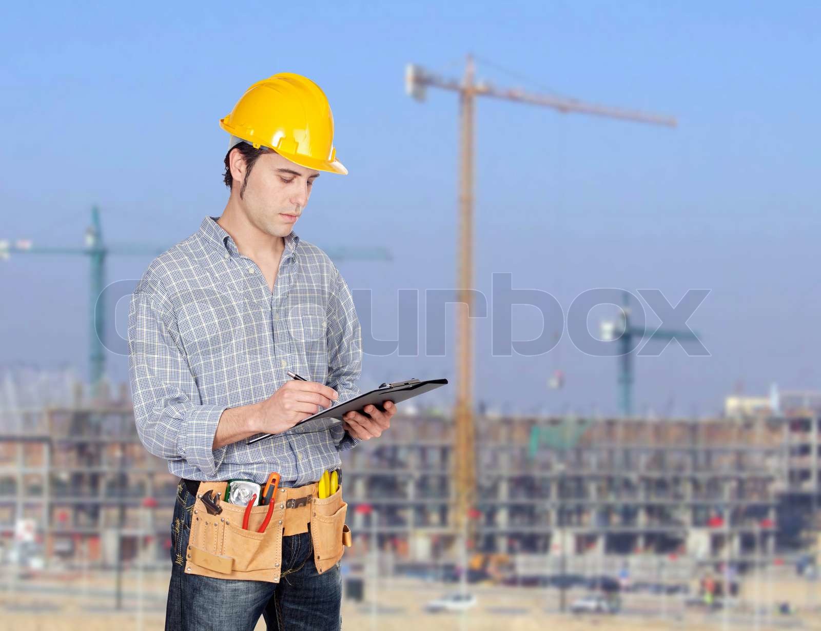 Construction worker writing paperwork | Stock image | Colourbox