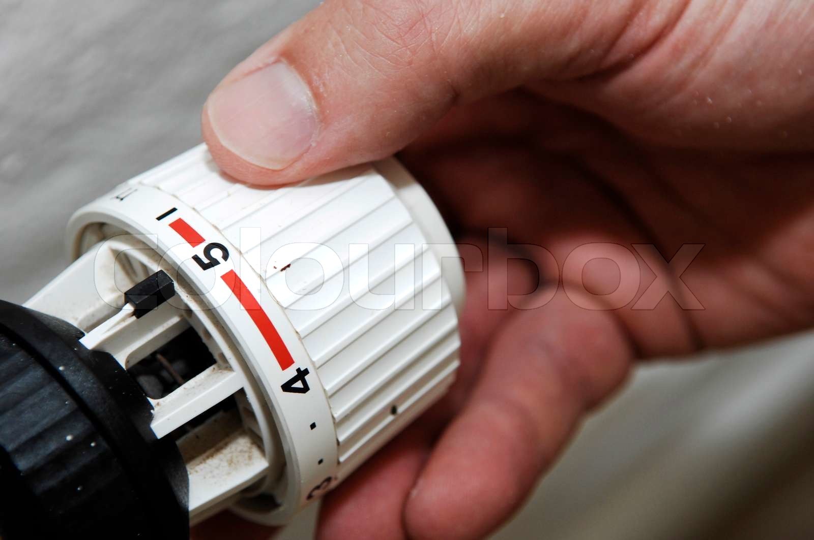 Close-up on male's hand turning on the radiator | Stock image | Colourbox